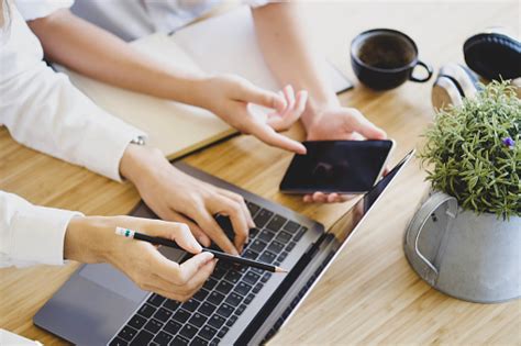 노트북 및 휴대 전화에 데이터와 함께 직장에 앉아 하는 동안 작업에 대해 두 명의 비즈니스 동료의 자른 2명에 대한 스톡 사진 및 기타 이미지 Istock