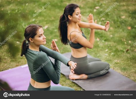 Top Back View Of Two Fit Girls Practising Yoga On Open Air On Warm