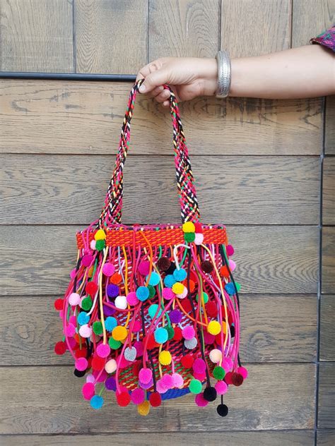 กระเป๋าสานจากสายลีซอ ชนเผ่าลีซอ สีสันสดใส แต่งปอมๆ ฟรุ้งฟริ้ง น่ารักค่ะ ขนาด กว้าง 13 สูง 11