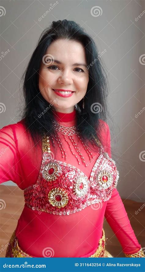A Dancer In A Red Suit Is Dancing An Oriental Dance On A White
