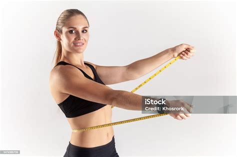 기뻐하는 스포티 한 금발 여자는 허리를 측정하면서 뱃속에 센티미터를 들고 있습니다 25 29세에 대한 스톡 사진 및 기타 이미지 25 29세 건강관리와 의술 건강한