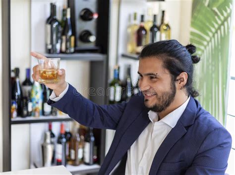 Latin Man In Suit Raising A Glass Of Whiskey In Toast Stock Image