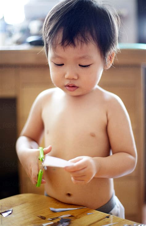 Cute Little Asian Girl Holding A Paper Cutting Scissors Del