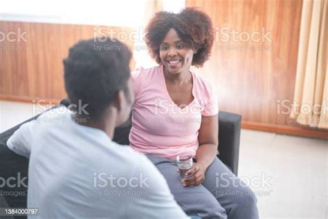 소파에서 말하는 목통에서 회복하는 행복한 아프리카 계 미국인 부부 2명에 대한 스톡 사진 및 기타 이미지 2명 가정 생활