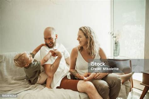 부모 자녀 그리고 가족과 함께 집 거실의 소파에 앉아 유대감을 형성합니다 어머니 아버지 아이들이 귀여운 아기와 장난기 많은 소년과 함께 라운지에서 웃고 있습니다 2 3 살에