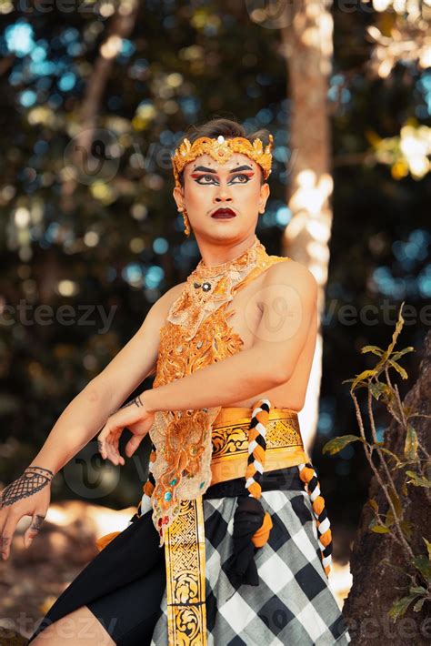 dançarina balinesa executa a dança em traje dourado e coroa dourada dentro do templo