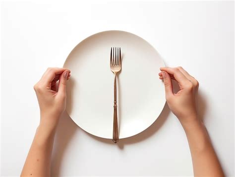 Mãos separando prato e garfo em imagens do dia mundial da alimentação de fundo branco Foto Premium
