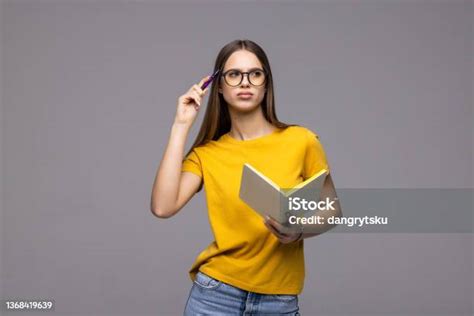 메모장에 메모를 하고 흰색 배경 위에 고립 된 복사 공간을 멀리 바라보는 여성의 초상화 여자에 대한 스톡 사진 및 기타 이미지 여자 책 펜 Istock