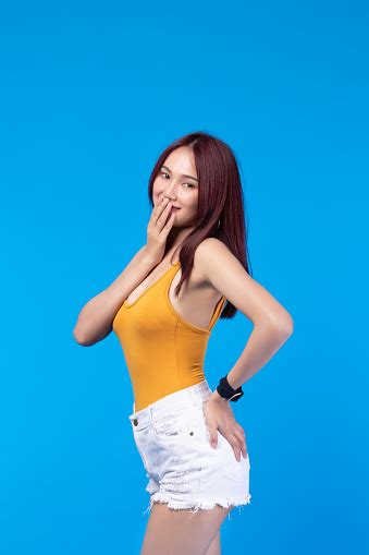 예쁜 노란색 조끼 흰색 반바지에 아름다운 젊은 아시아 여성의 패션 파란 배경에서 웃고 있는 소녀 패션 아름다움과 스타일 가을에 대한 스톡 사진 및 기타 이미지 Istock