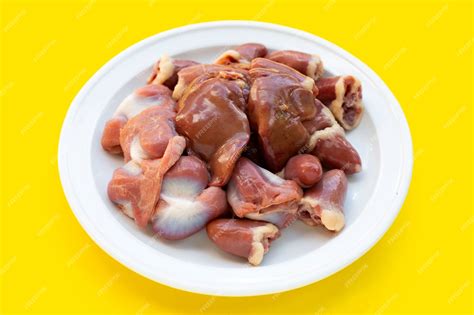 Premium Photo Mixed Chicken Entrails In White Plate On Yellow Background