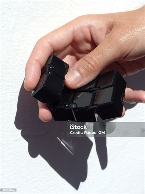 검은 색 무한대 큐브와 함께 재생 큐브로 다른 모양을 만들고 흰색 벽에 그림자를 만드는 손 3차원 형태에 대한 스톡 사진 및 기타 이미지 Istock