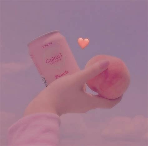 A Hand Holding Up A Pink Doughnut With A Heart Shaped Object In The