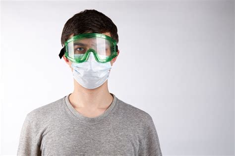 백인 남성은 흰색 배경 위에 캐주얼 옷을 입고 복사 공간을 복사합니다 파란 눈을 가진 중반 나이 남자 보호 안경과 얼굴 마스크를