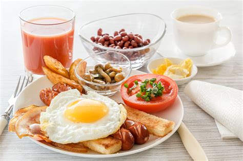 훈제 소시지 계란 베이컨 토마토 토스트 콩와 함께 전체 영어 아침 식사 우유와 차입니다 신선한 주스의 유리입니다 칼 붙 이입니다