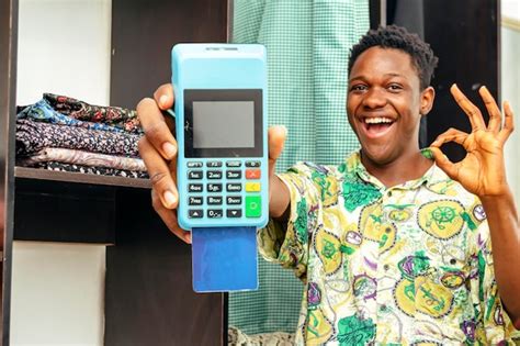Premium Photo Young African Man Using A Handheld Pos System For Small