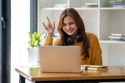 원격 교육 E러닝 온라인 학습 책상에 앉아 헤드폰 헤드 세트를 착용하고 웃고 있는 아름다운 여성 학습 온라인 수업 줌 구글 미팅 디스코드 학습을 위해 참석하는 행복한 약혼