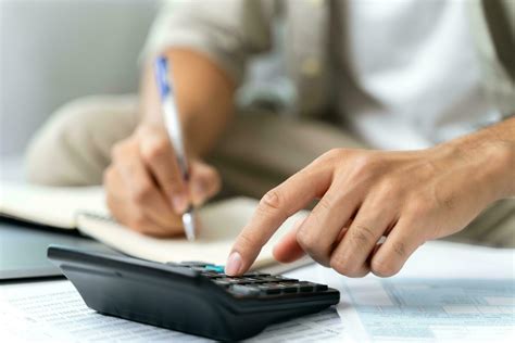 el hombre está calculando el impuesto anual con calculadora y llenando