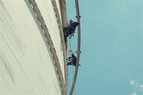 남성 작업자 로프 접근 높이 안전 점검 두께 저장 오일 및 가스 탱크 프리미엄 사진