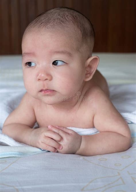 Soft Focus On Adorable Naked Curious Infant Baby Lay On Stomach On The