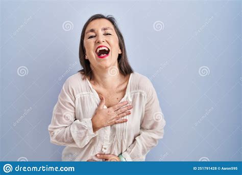 Middle Age Hispanic Woman Standing Over Blue Background Smiling And