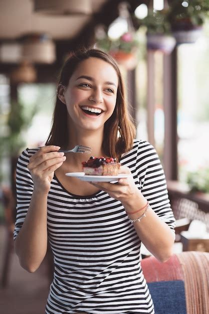 Jeune Femme Manger Gâteau Au Fromage Aux Fraises Photo Gratuite