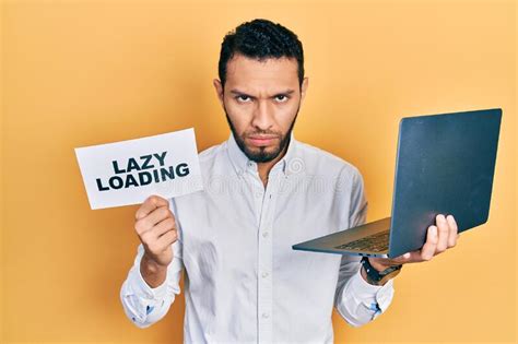 Hispanic Man With Beard Working Using Computer Laptop Holding Lazy