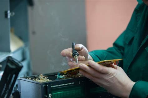 Premium Photo Hands Solder A Soldering Iron Board