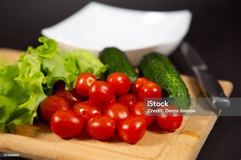 신선하고 육즙이 풍부한 체리 토마토 오이 거킨 양상추 잎 나무 도마에 물 방울이 있습니다 농부의 신선한 야채 건강한 생활방식에