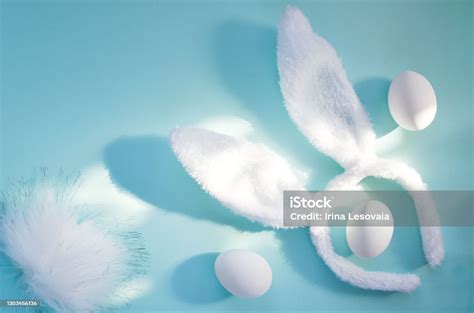 토끼 귀와 꼬리는 밝은 파란색 배경에 흰색 닭 계란 사이에 거짓말 부활절 카니발 4월에 대한 스톡 사진 및 기타 이미지 4월