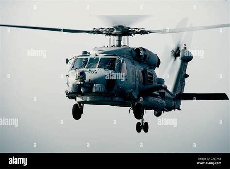 An Mh R Seahawk Attached To Helicopter Maritime Strike Squadron Hsm Hovers Over The Water