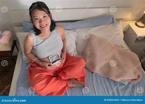 Lifestyle Home Portrait Of Young Happy And Beautiful Asian Japanese Woman Pregnant Sitting On