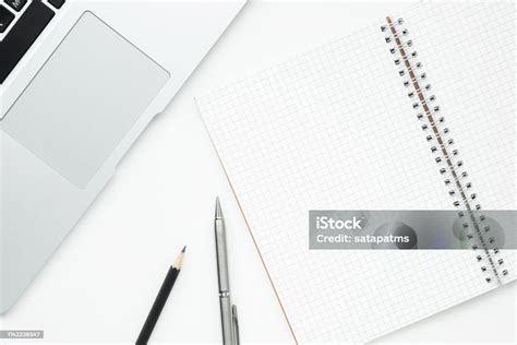 그리드 라인이 있는 빈 노트북은 노트북 컴퓨터 펜 및 연필로 흰색 사무실 책상 테이블 위에 있습니다 평면도 평 신도 계획에 대한