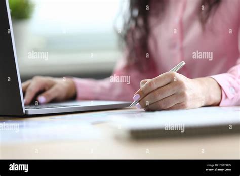 Woman Makes Notes With Pen On Sheet And On Laptop Stock Photo Alamy
