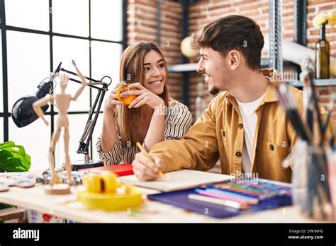 Mand And Woman Artist Couple Drinking Coffee Drawing On Notebook At Art