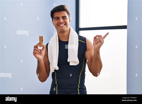 Hispanic Man Eating Protein Bar As Healthy Energy Snack Smiling Happy