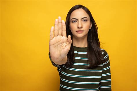 젊은 숙녀들 에서 착용 T셔츠 서 있는 통하고 있는 노란 배경 스톡 사진 그만해 손짓에 대한 스톡 사진 및 기타 이미지 그만해 손짓 정지 표지판 손 Istock