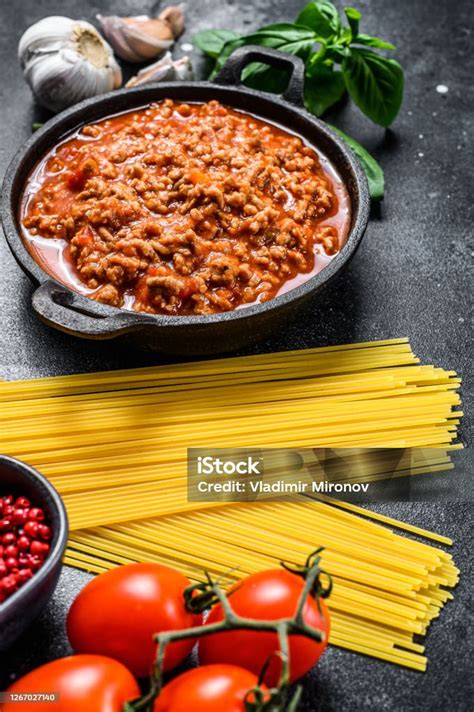 스파게티 볼로네즈의 이탈리아 식재료 생 파스타 바질 갈은 쇠고기 토마토 검은 색 배경 위쪽 보기 가루로 빻은에 대한 스톡 사진