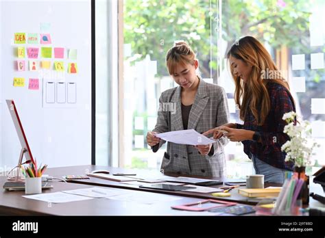 Two Young Women Designer Brainstorming And Working On Mobile App Interface Wireframe Design