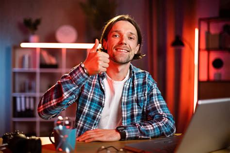 책상에 앉아 가슴에 손을 얹고 카메라를 바라보는 매력적인 남자 30 34세에 대한 스톡 사진 및 기타 이미지 30 34세 가정 생활 거실 Istock