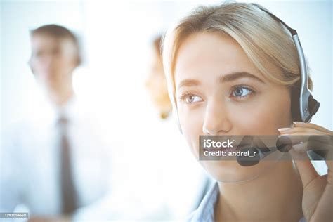 헤드폰 컨설팅 클라이언트와 쾌활한 미소 사업가 햇볕이 잘 드는 사무실에서 일하는 다양한 전화 사업자 그룹 콜센터 및 비즈니스