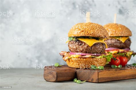 가벼운 콘크리트 배경에 쇠고기 베이컨 치즈 양상추 토마토의 수제 맛있는 햄버거 세트 지방 건강에 해로운 음식 클로즈업 복사 공간