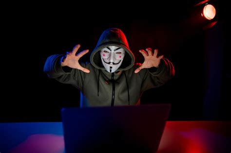 Premium Photo Anonymous In A Hood Is Typing On A Laptop In The Dark