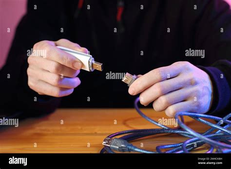 Connecting A Card Modem To A Blue Usb Cable By A Person In A Black