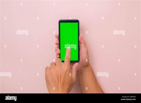 Mano humana usando smartphone móvil con pantalla verde de maqueta sobre
