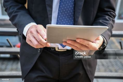외부 건물에 서 있는 동안 터치 패드를 잡고 한 벌에서 사업가 야외 작업에 대 한 디지털 태블릿을 사용 하 여 아시아 젊은이