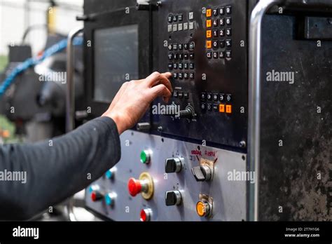 Unrecognizable Operator Touching The Panel Of A Numerically Controlled