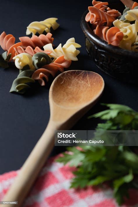 삼색 푸실리 국수와 체리 둥근 토마토 칠리 페퍼 마늘 파슬리가 있는 에바노 블랙 볼 식품 원료 개념 45도 각도 0명에 대한