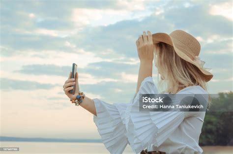 스마트 폰에서 셀카를 찍는 소녀의 초상화 젊은 아름다운 30 년 여성 백인 모양에 빨대 모자와 사틴 리본 활 공간을 복사합니다