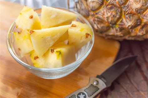 파인애플 조각과 조각을 잘라 내고 자마위에 보관된 전체 파인애플과 칼 외에 테이블에 유리 제품으로 보관한 조각을 닫습니다 건강한 식생활에 대한 스톡 사진 및 기타 이미지