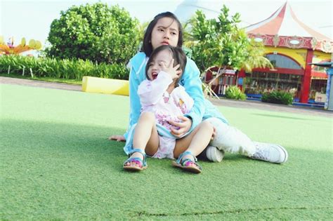 Premium Photo Cute Siblings Sitting In Park